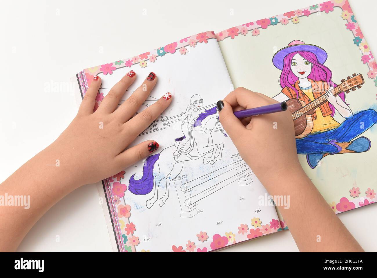 Closeup of a female hand coloring picture with a purple marker Stock ...