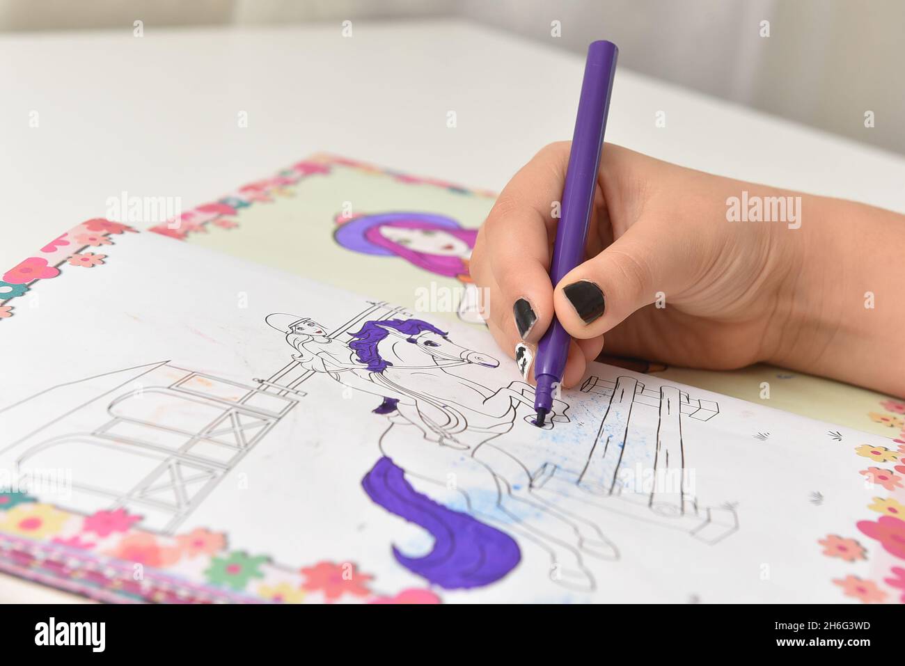 Closeup of a female hand coloring picture with a purple marker Stock ...