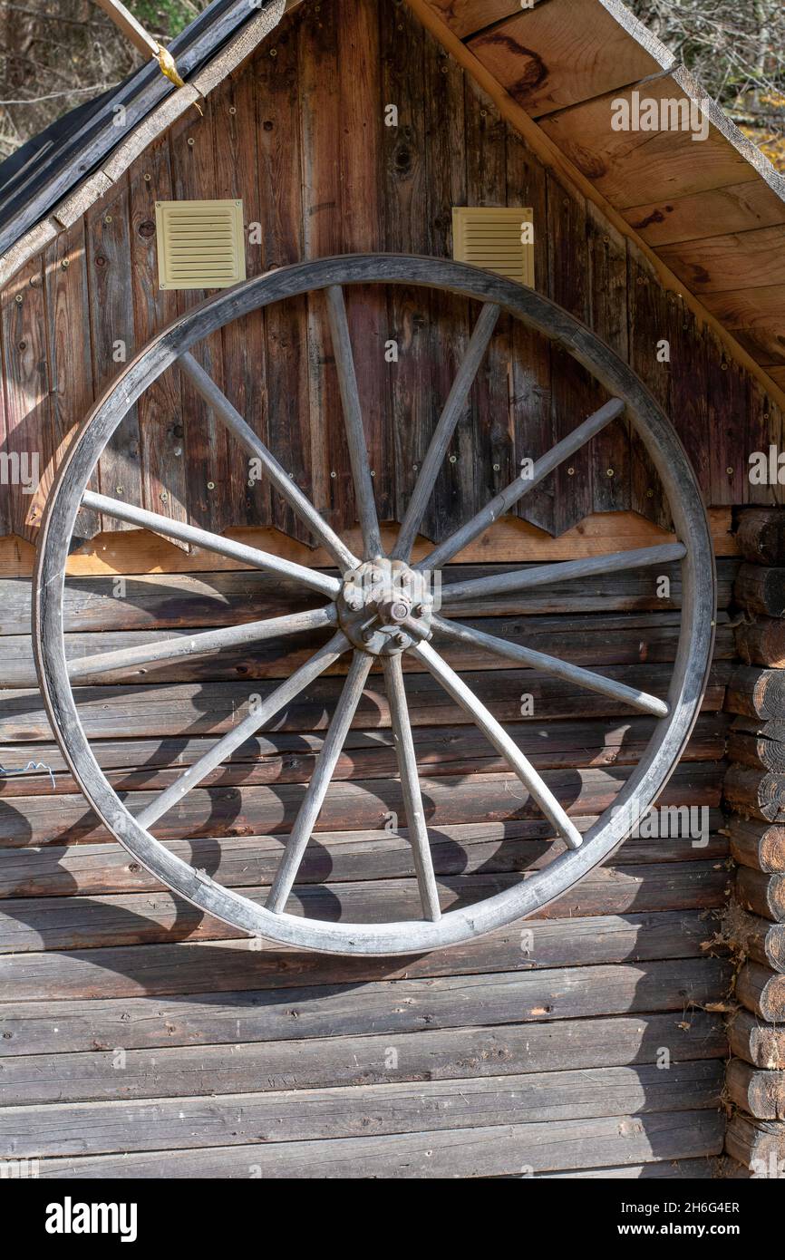 An old wooden wagon wheel hanging on the wall of a barn Stock Photo - Alamy