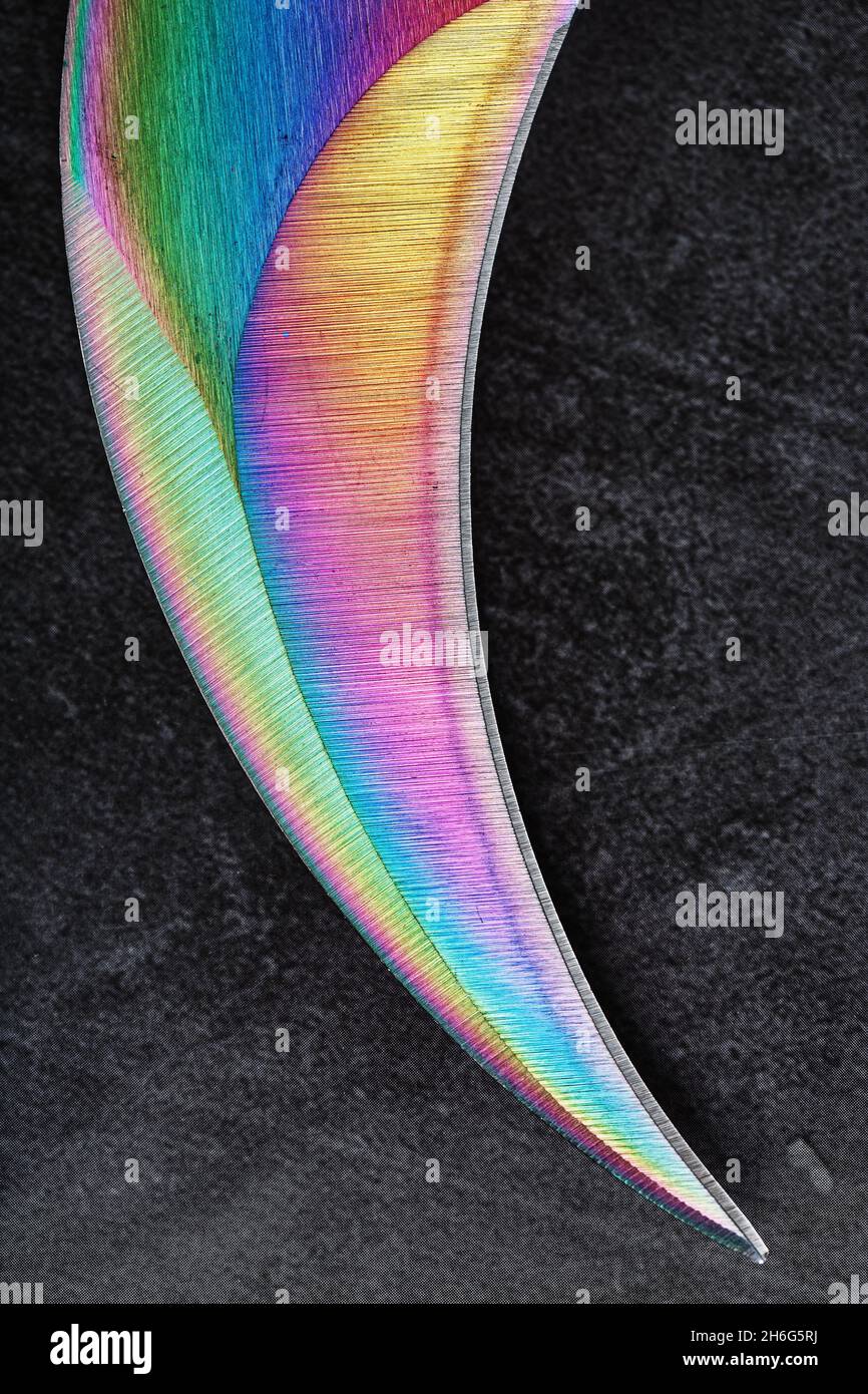 The curved sharp blade of the Kerambit Dagger is a gradient rainbow ...