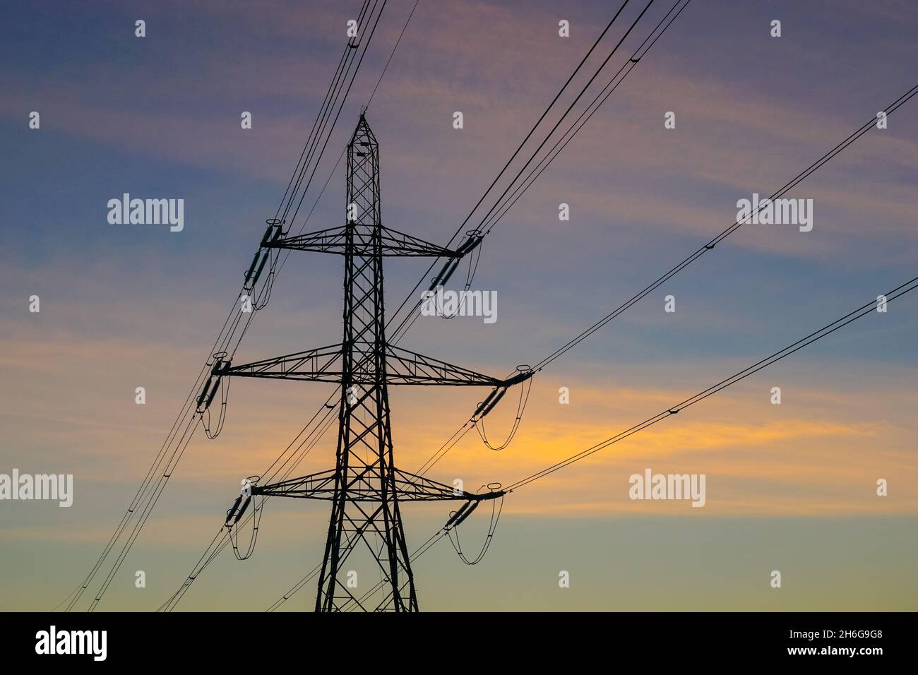 Electricity pylon and colorful sunset sky Stock Photo - Alamy