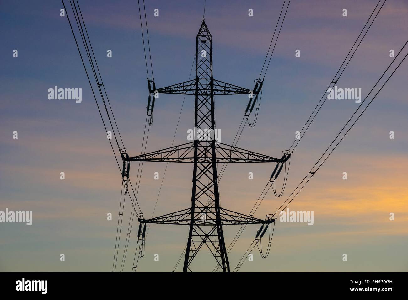 Electricity pylon and colourful sunset sky Stock Photo - Alamy