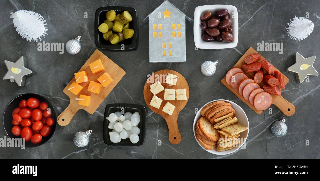 Tasty array of meats, cheeses and condiments on a dark marble ...