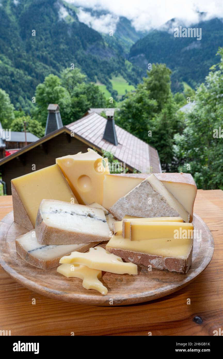 Cheese collection, wooden board with French cheeses comte, beaufort ...