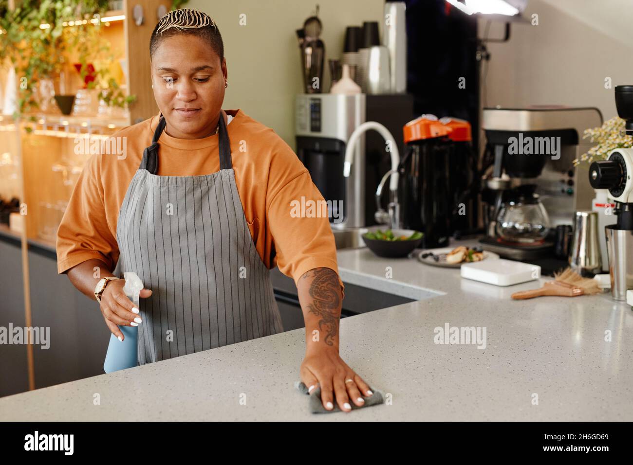 Horizontal high angle medium portrait of young woman washing cafe ...