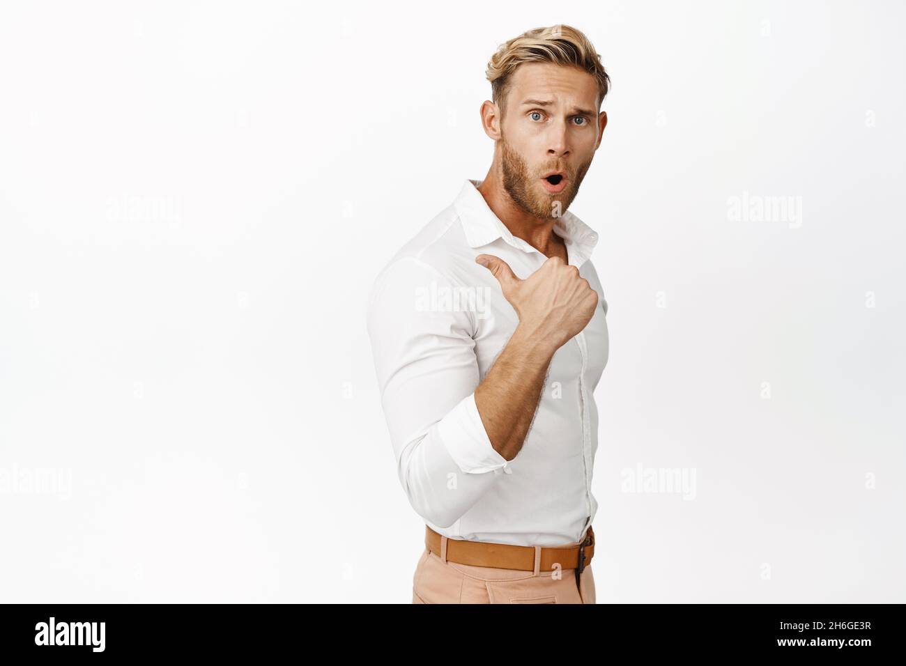 Portrait of handsome caucasian man looking amazed by product, pointing ...
