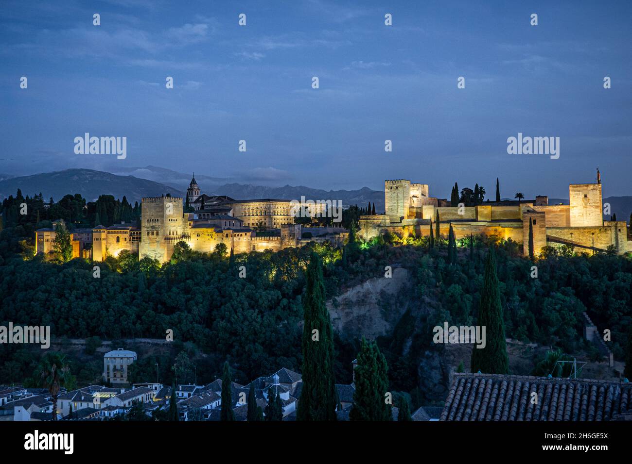 Landscape of The Alhambra palace surrounded by greenery in the evening ...