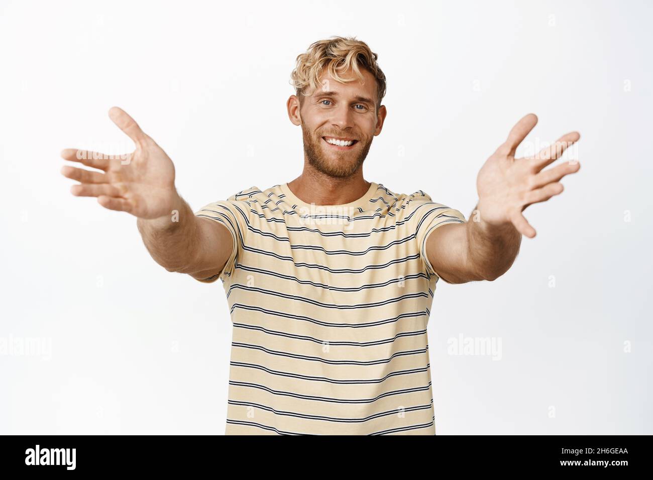 Handsome blond man stretching hands and smiling, inviting for hug ...