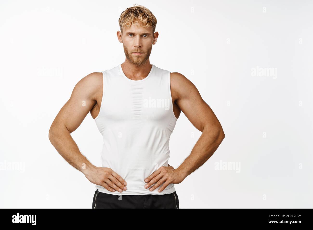 Image of sportsman looking serious, showing his biceps on arms, strong ...