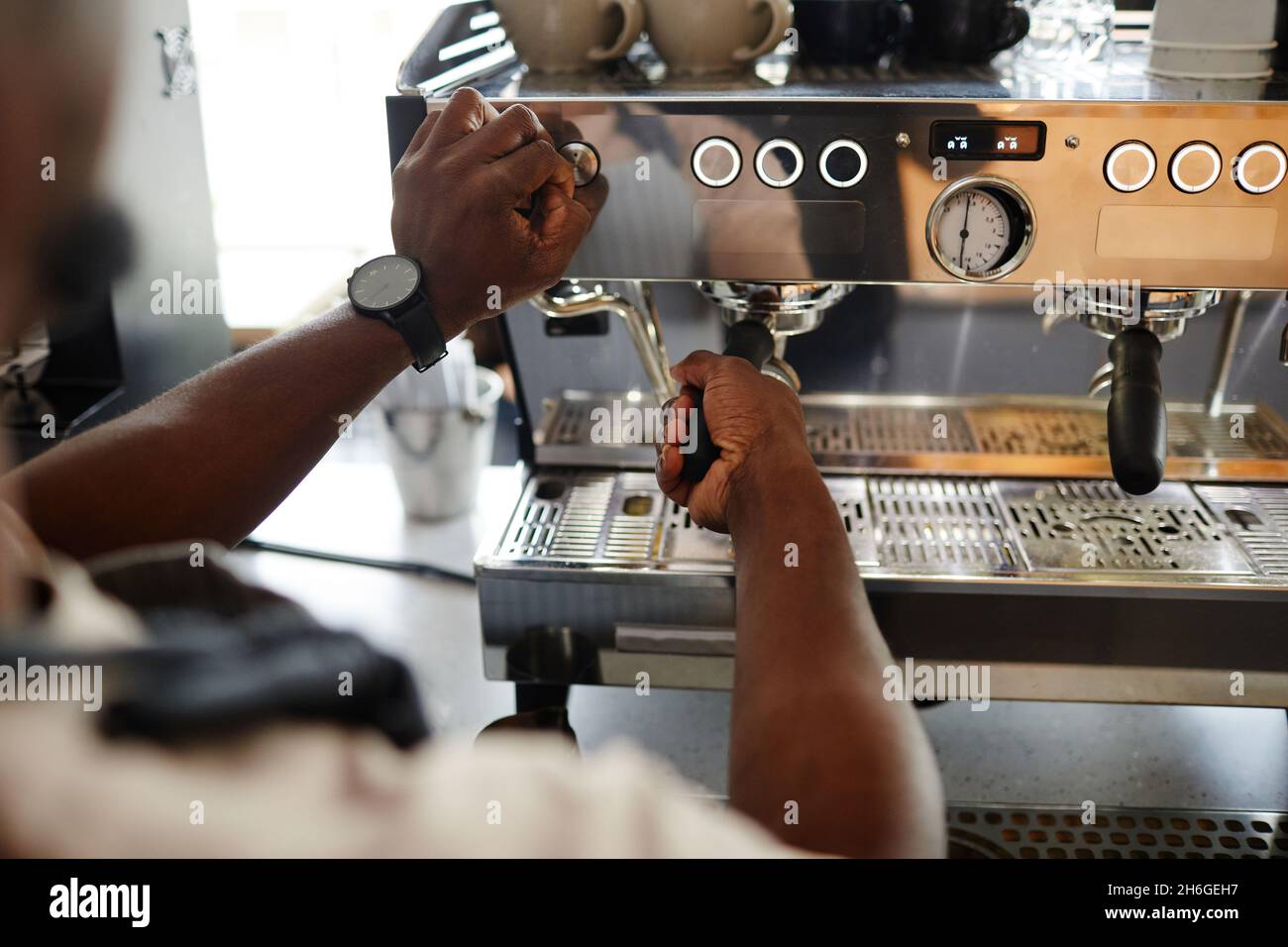 High angle shot of unrecognizable barista adjusting settings on ...