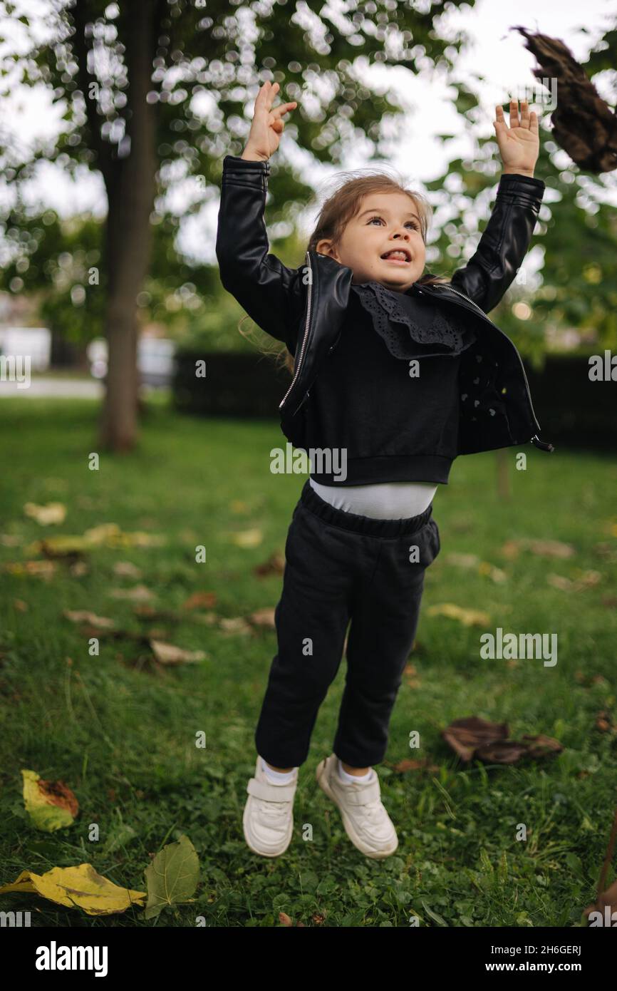 Beautiful little girl walking in the park. Happy kid outdoor. Autumn ...