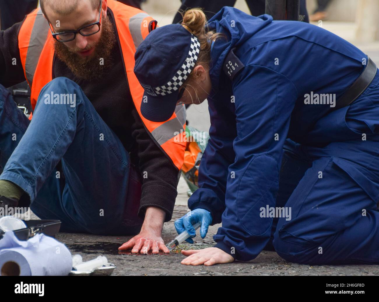 London, UK. 4th November 2021. A police officer dissolves the glue on a ...