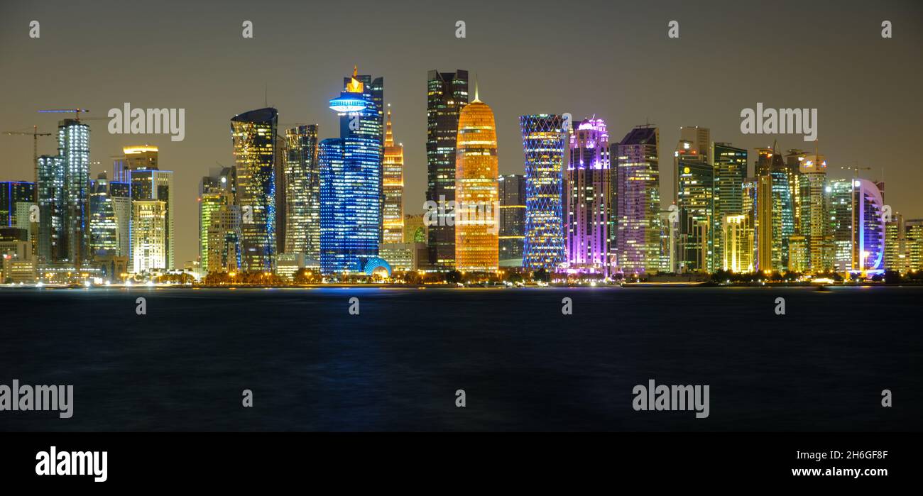 Doha Qatar skyline at night showing skyscrapers lights reflected in the ...