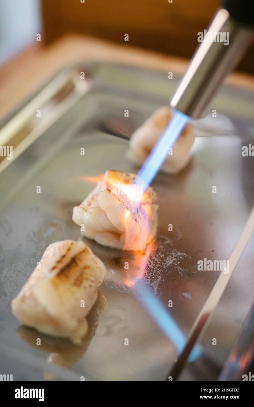 Closeup shot of fish slices being burnt in a kitchen of a restaurant ...