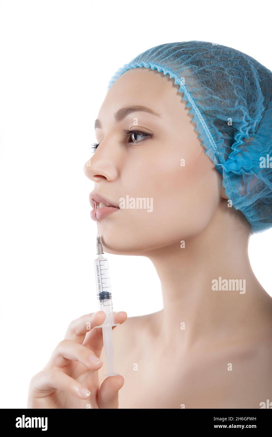 woman gets an injection in her lips. Isolated over white background ...