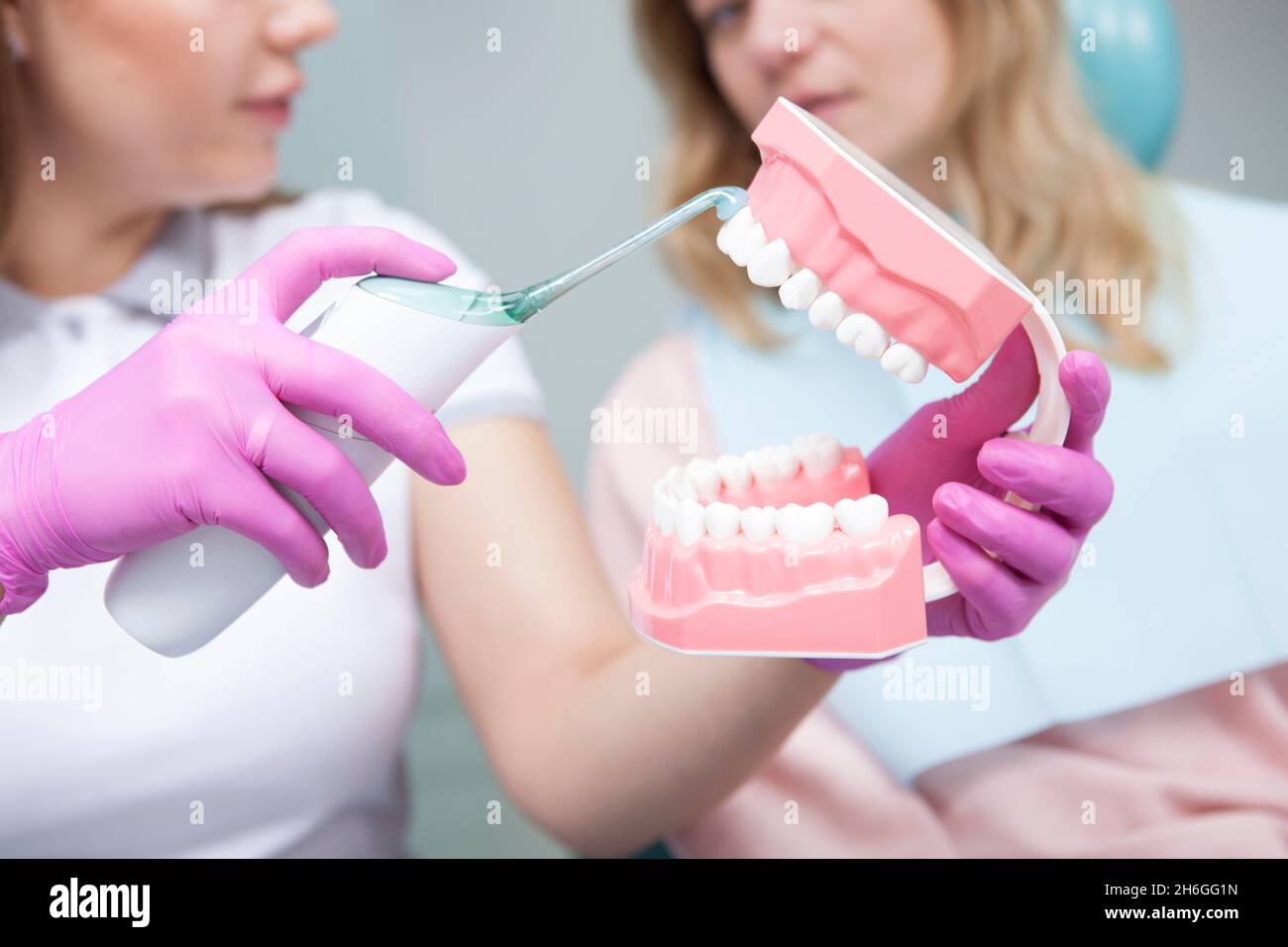 Dentist educating her patient, showing how to clean teeth with ...