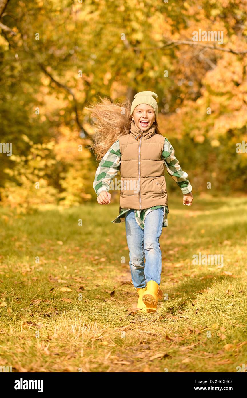 A girl in warm clothes playing in the park Stock Photo - Alamy