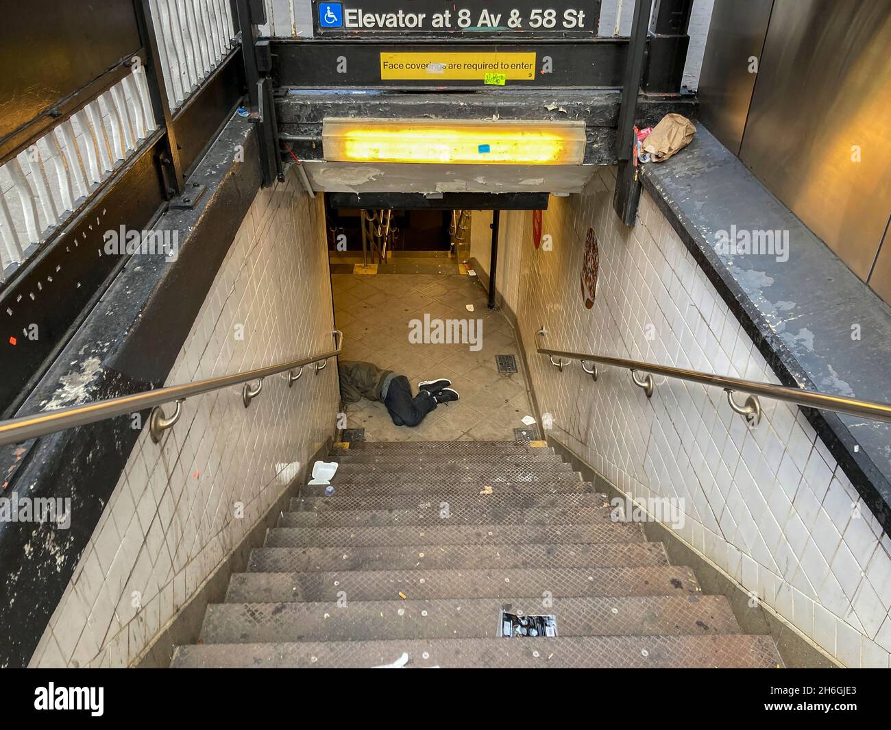 A homeless man sleeps at the entrance to a subway station in New York ...