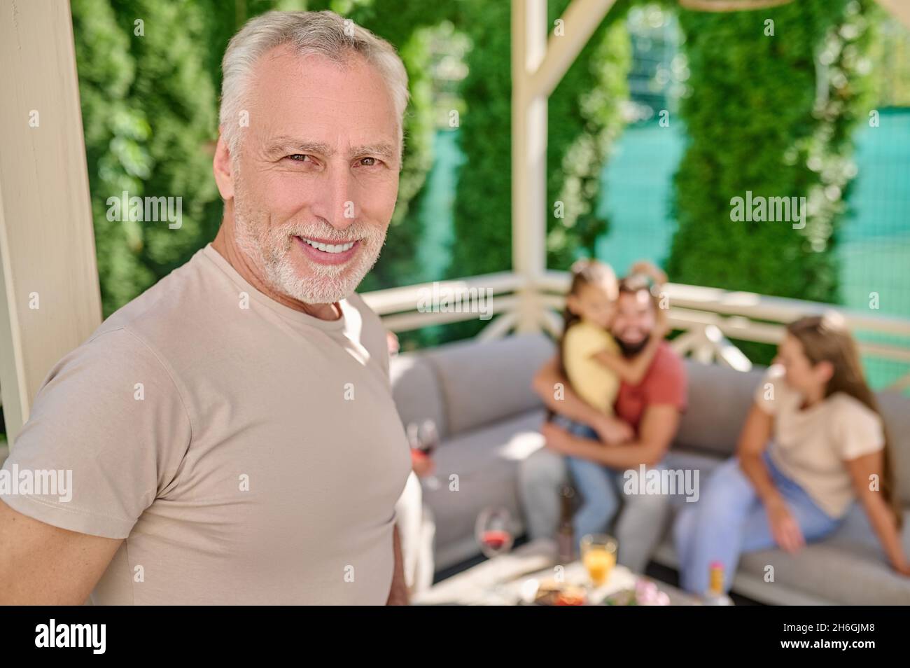 A gray-haired man standing and looking happy Stock Photo - Alamy