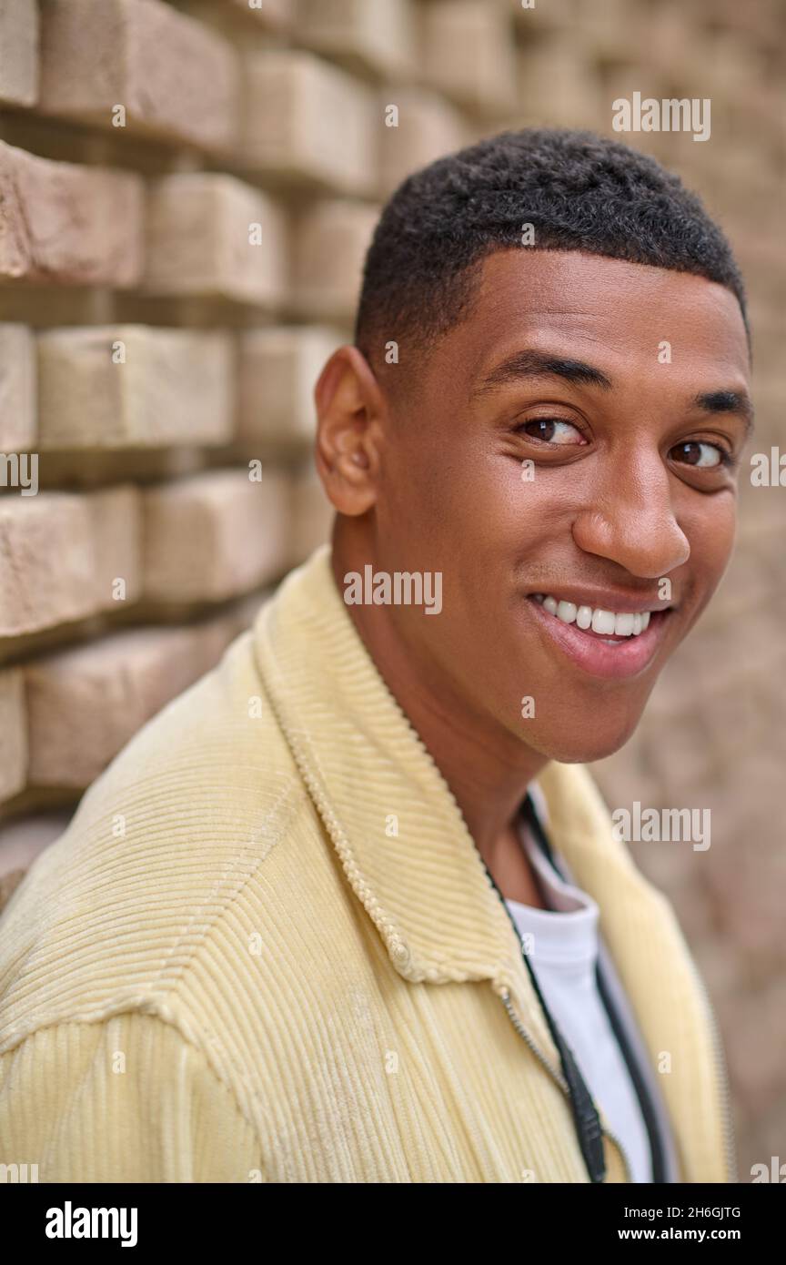 Headshot of young dark-skinned man in beige jacket Stock Photo - Alamy