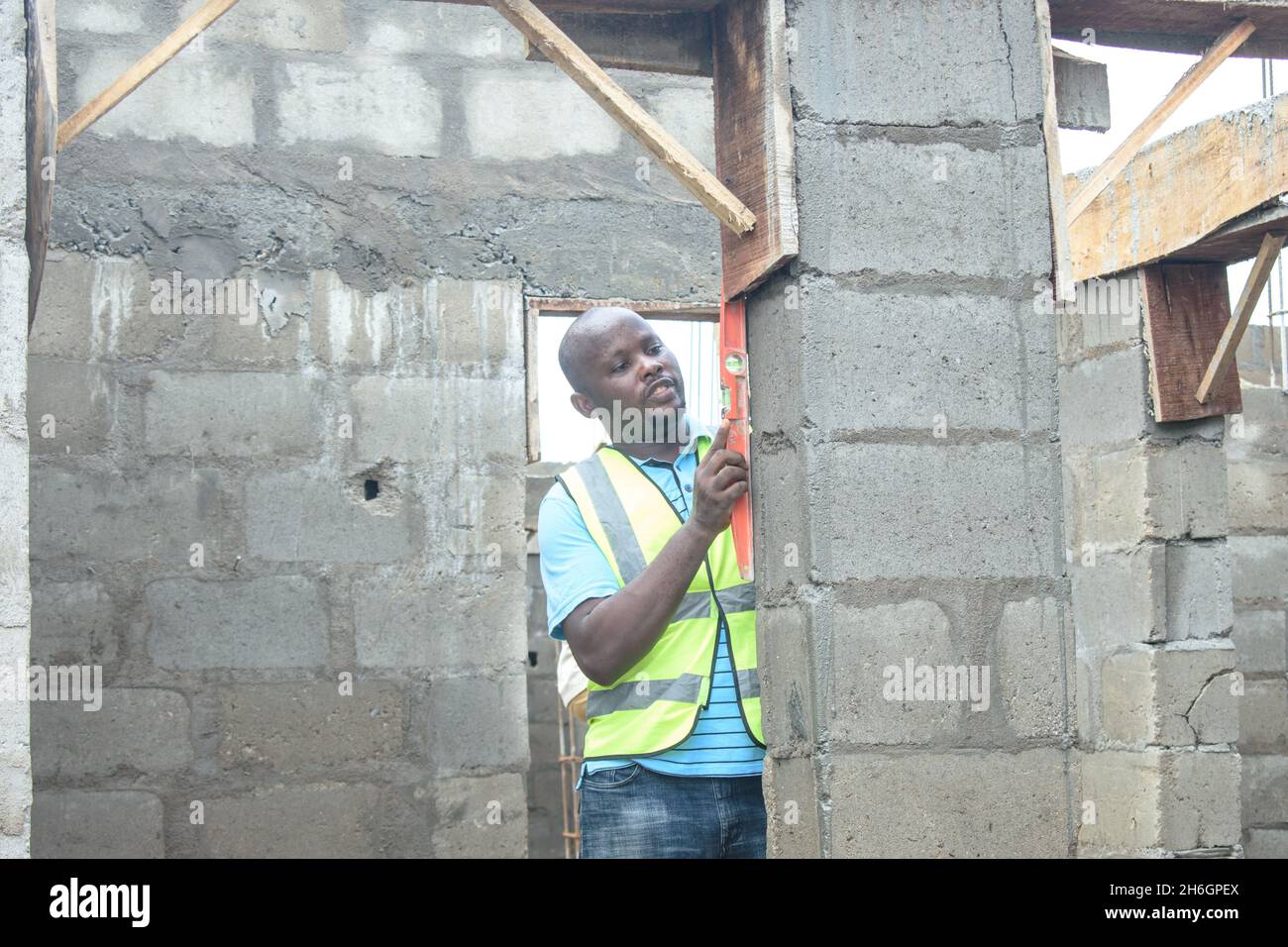 African male construction worker working with a level gauge on a ...