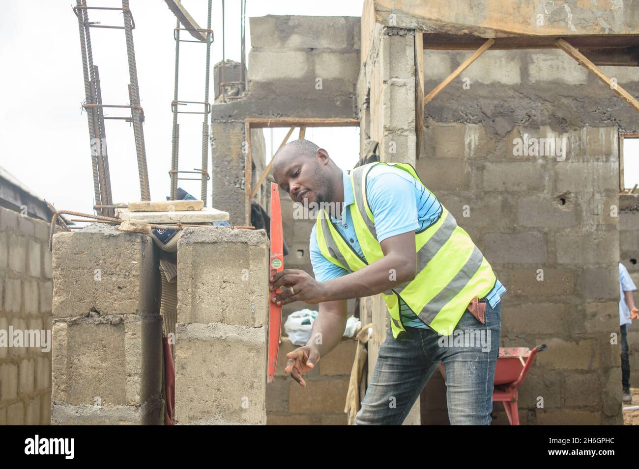African male construction worker working with a level gauge on a ...
