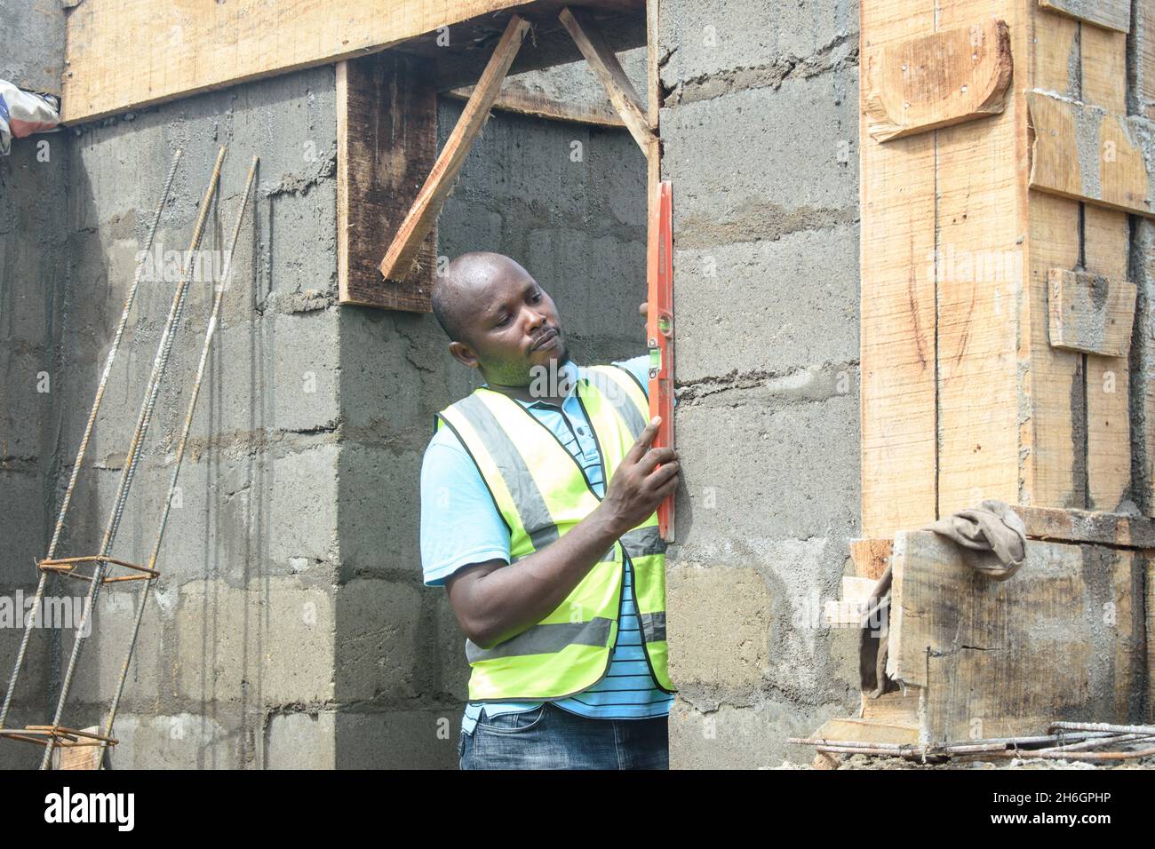 African male construction worker working with a level gauge on a ...