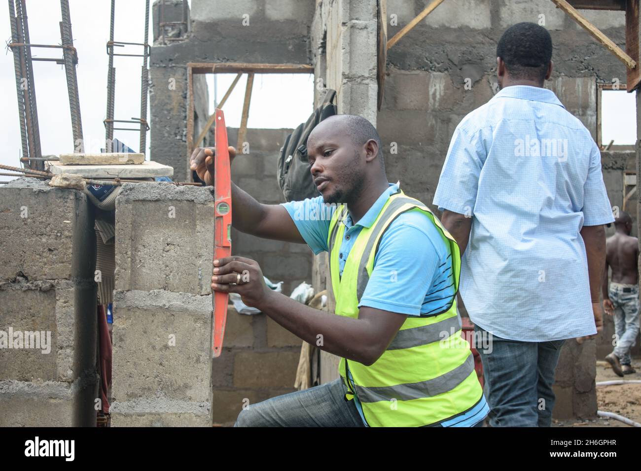 African male construction worker working with a level gauge on a ...