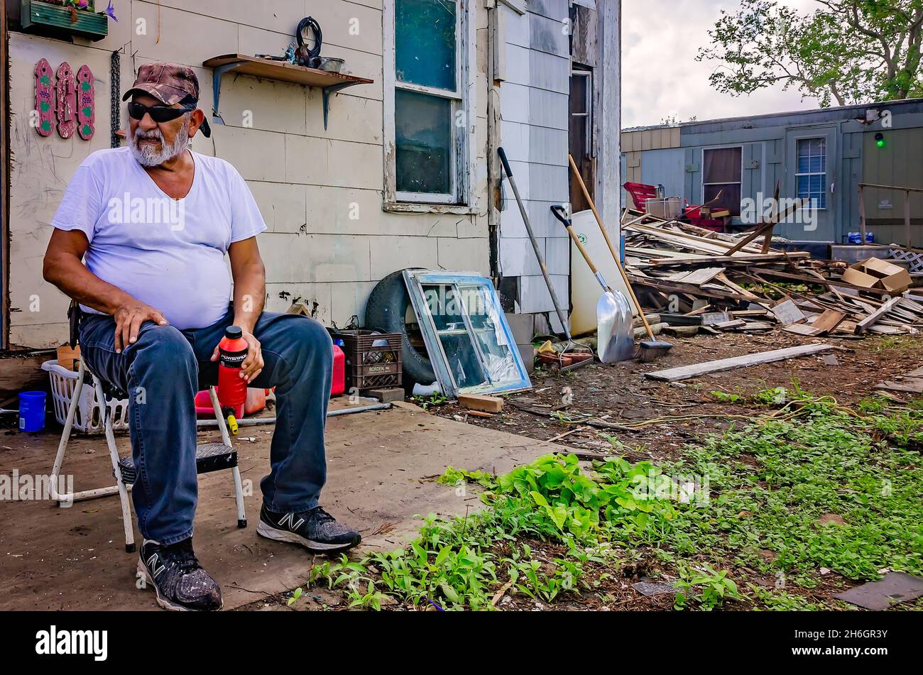 Joe Guerra sits in front of his storm-damaged house as he waits for his ...
