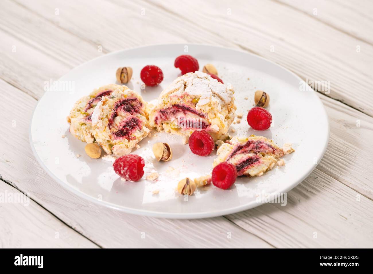 Tasty sweet roll cake with pistachios and raspberry on the plate Stock ...