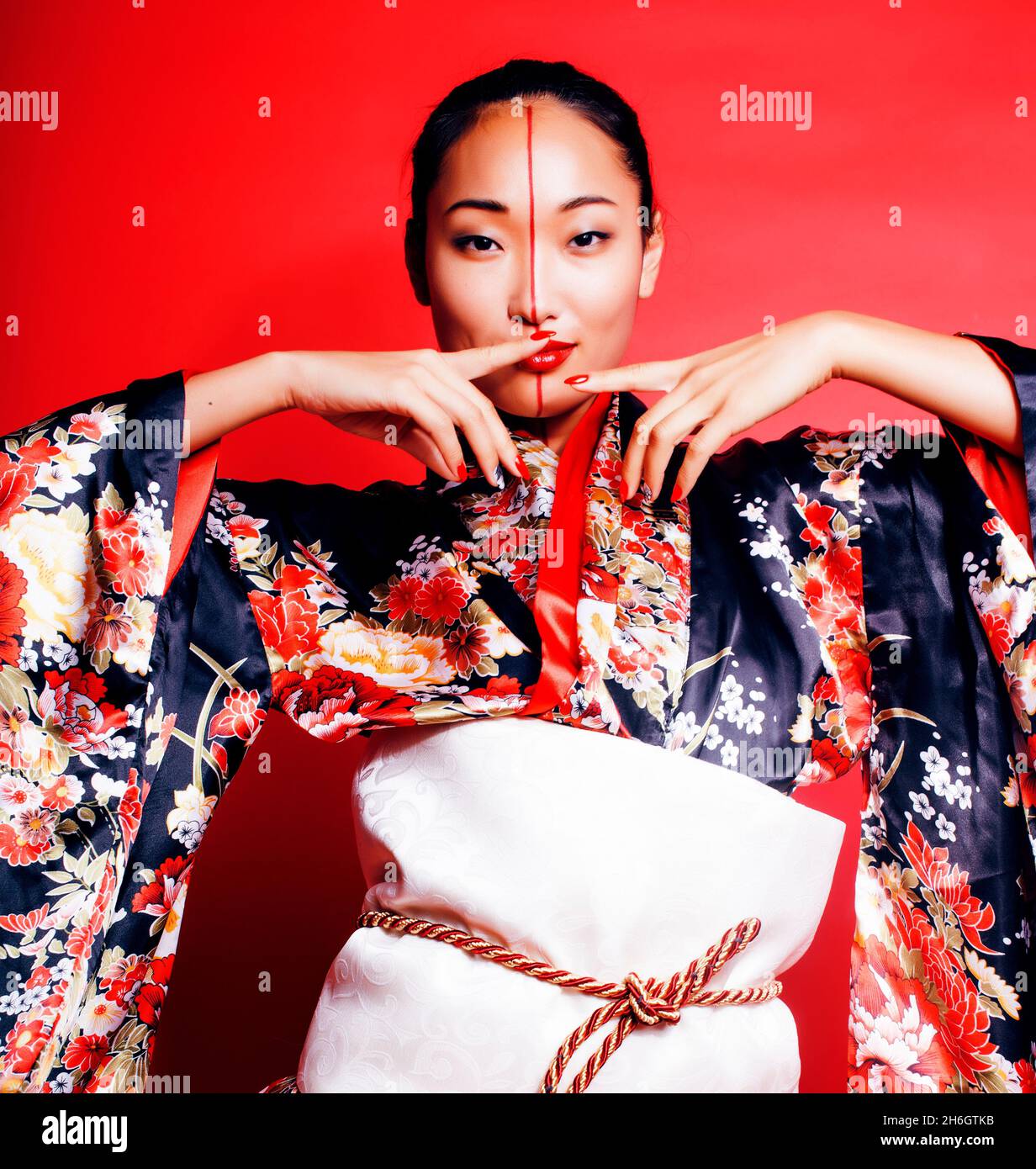 young pretty geisha on red background posing in kimono, oriental Stock ...