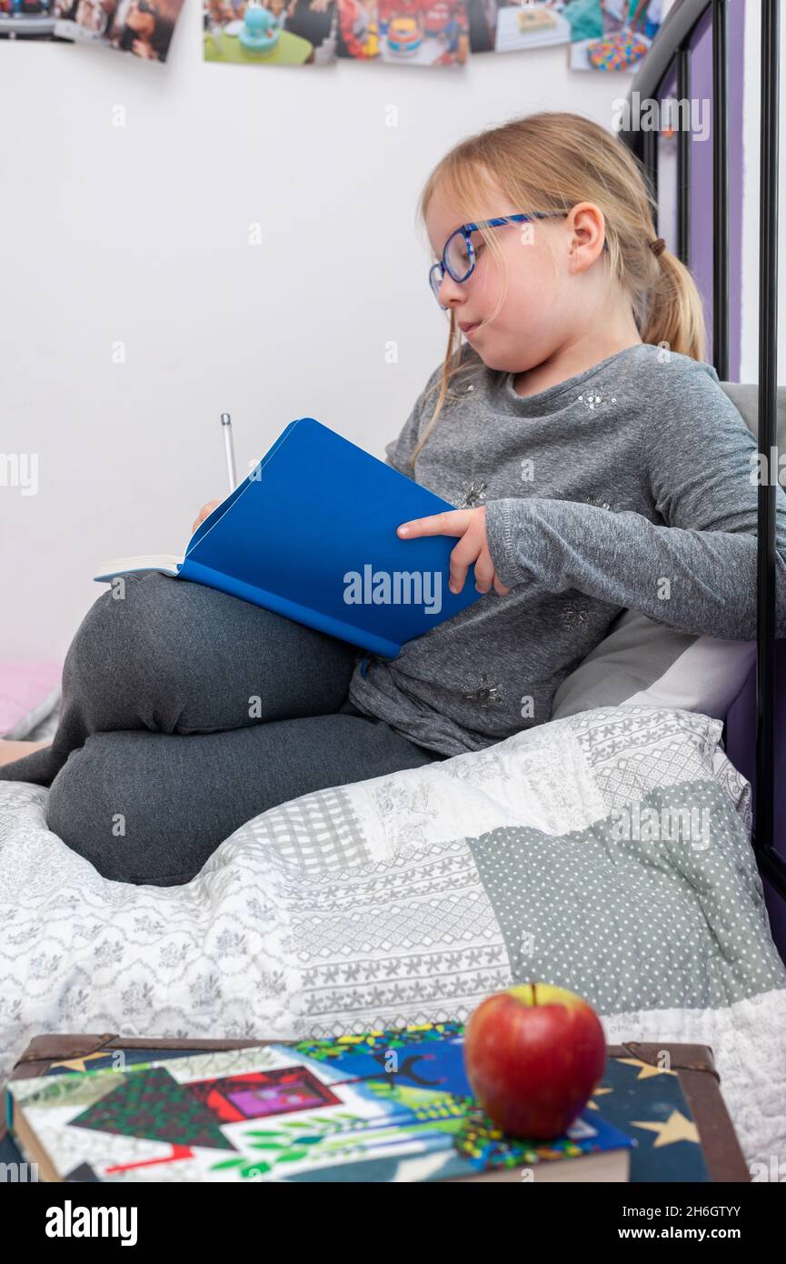 School age girl sitting in her bedroom and doing school homework Stock ...