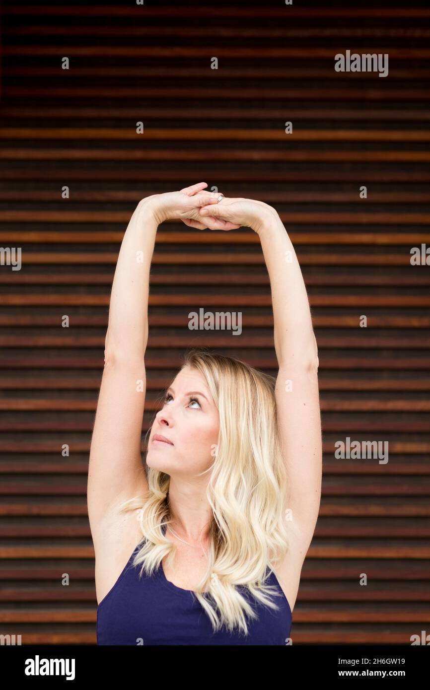 Attractive woman in thirties stretching arms above her head Stock Photo ...