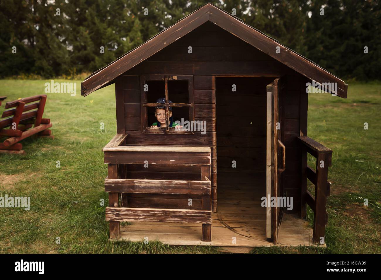 Small boy peaking through window of tiny wooden house Stock Photo - Alamy