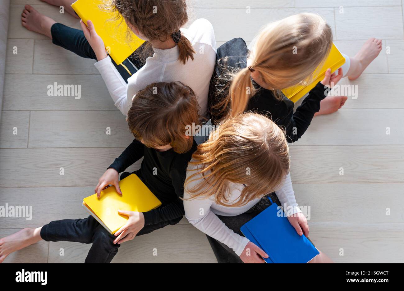 Four children on floor in living room doing prep work for school ...