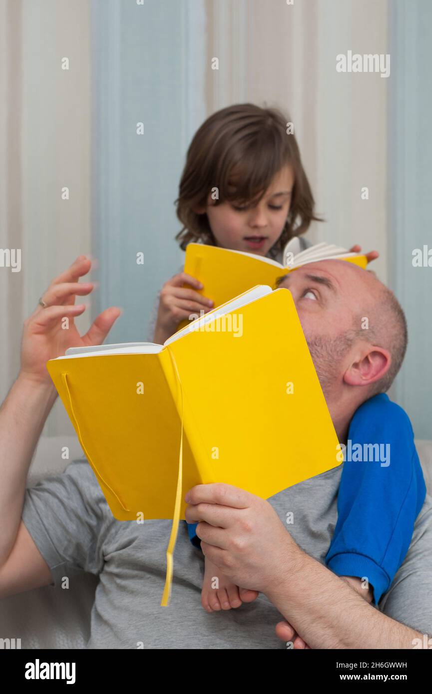 Father and son together enjoying reading and discussing school homework ... Father and son together enjoying reading and discussing school homework ...