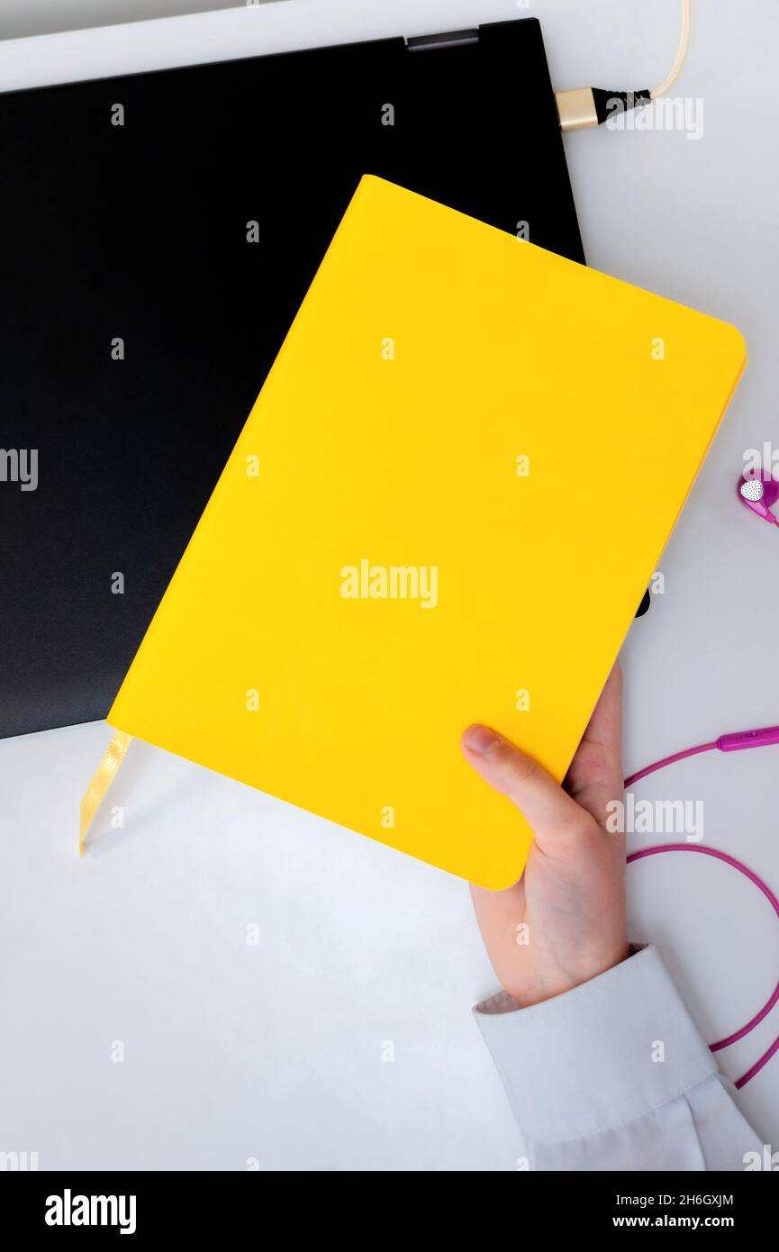 Flat lay with a yellow book for copy space and electronic devices ...