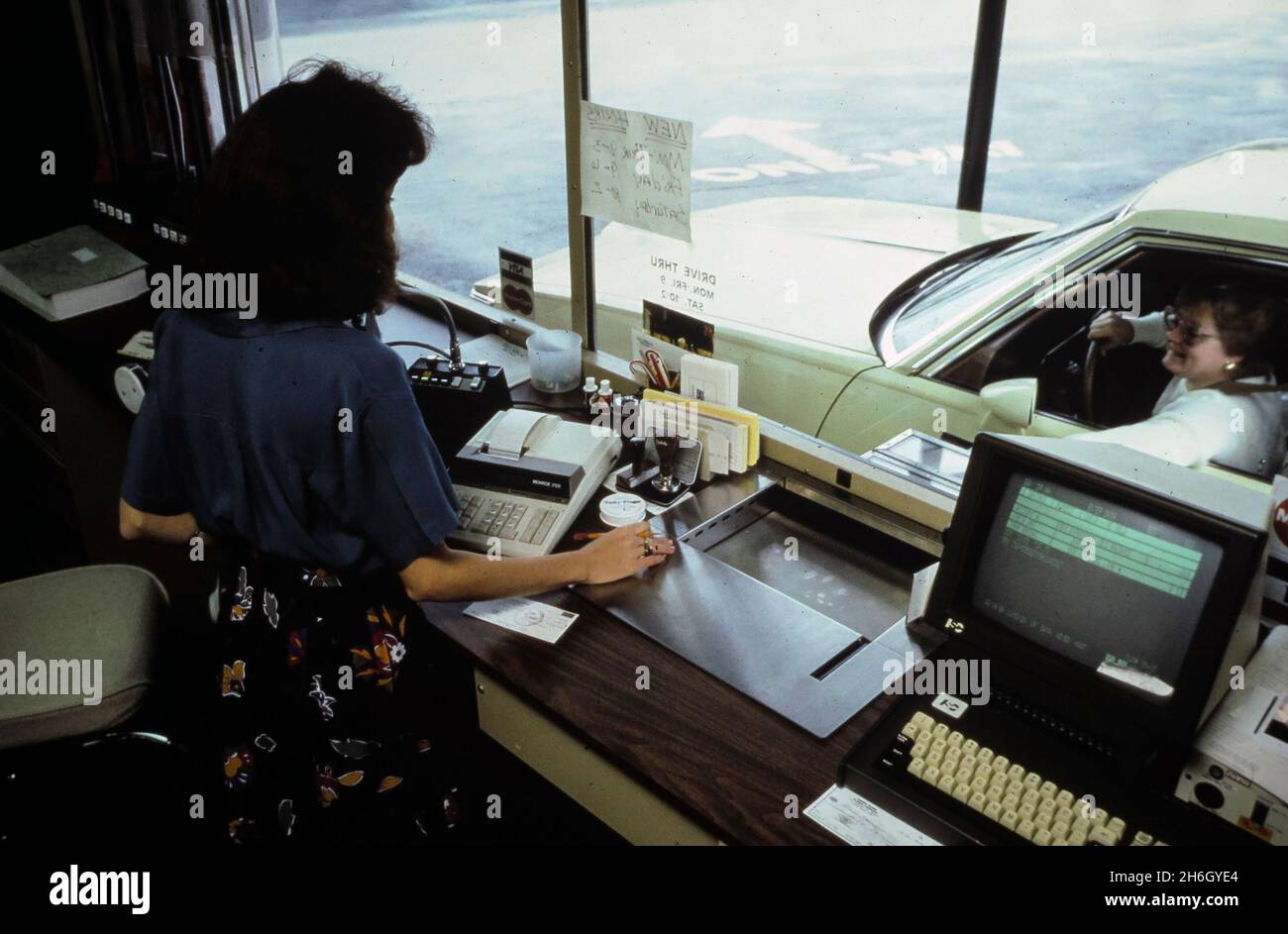 Austin Texas USA, circa 1989: A female bank teller works at the drive ...