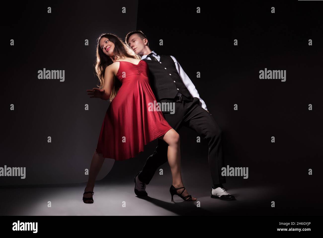 Man and woman in the most romantic dance tango over dark background ...