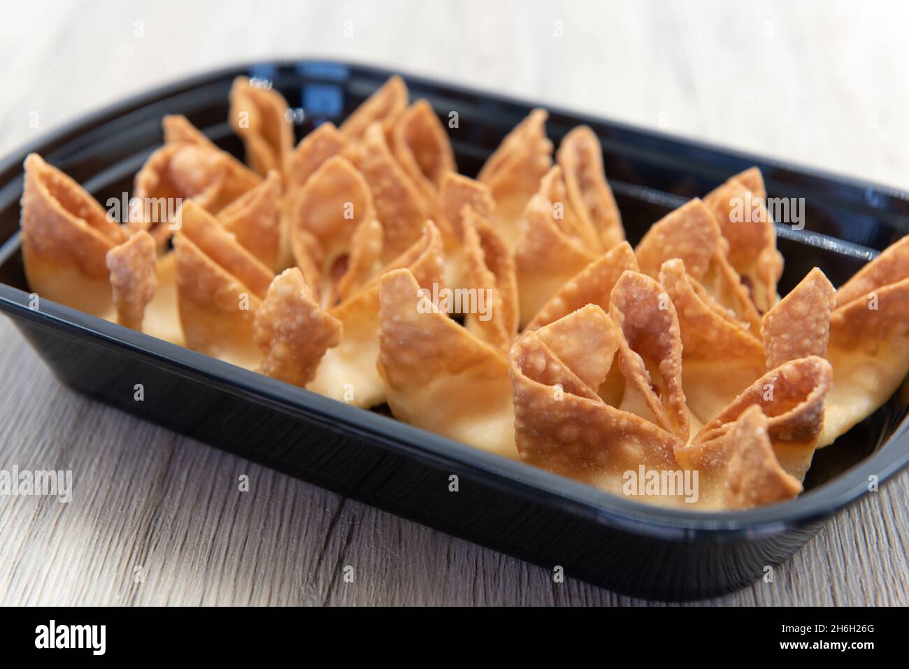 Fried wontons all symmetrically folded and arranged on a plate as a ...