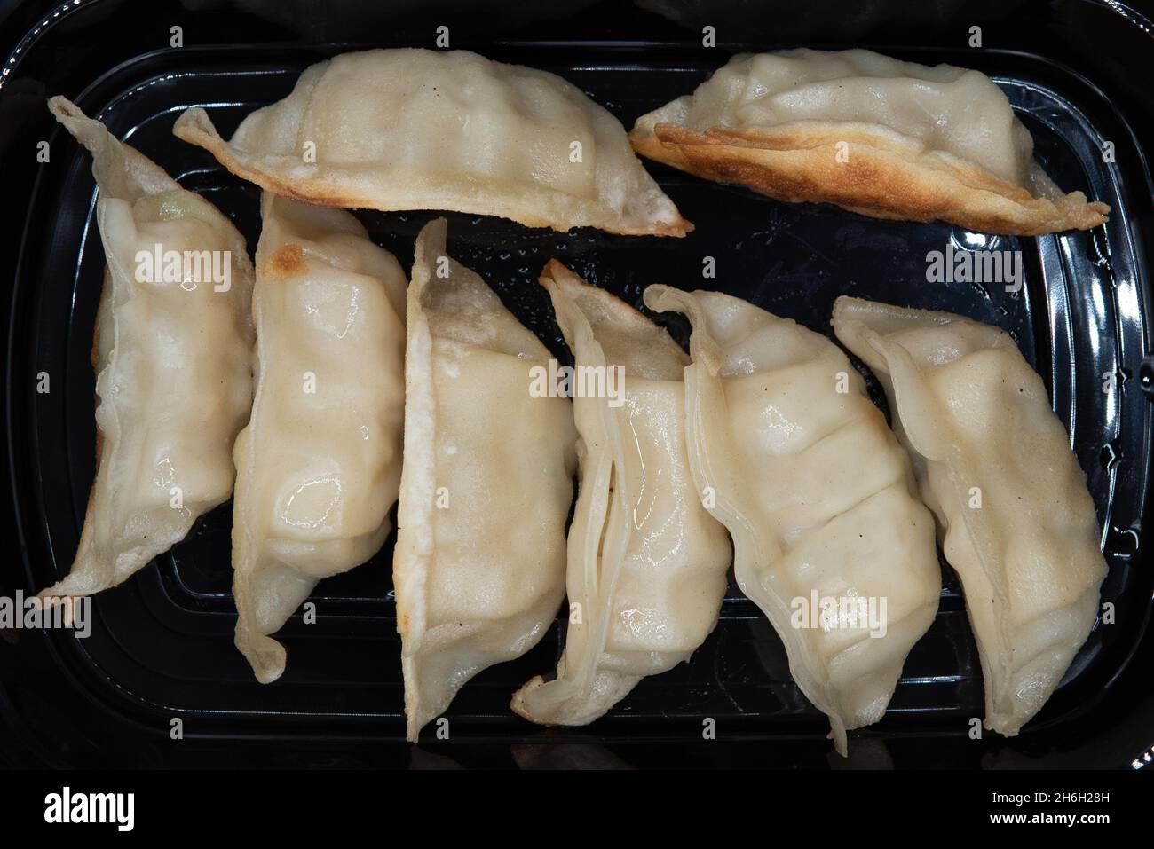 Overhead view of boiled and fried dumpling pot stickers make the ...