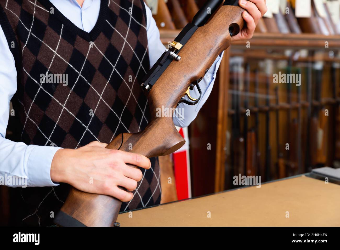 Air rifle in the hands of the owner of gun shop Stock Photo - Alamy