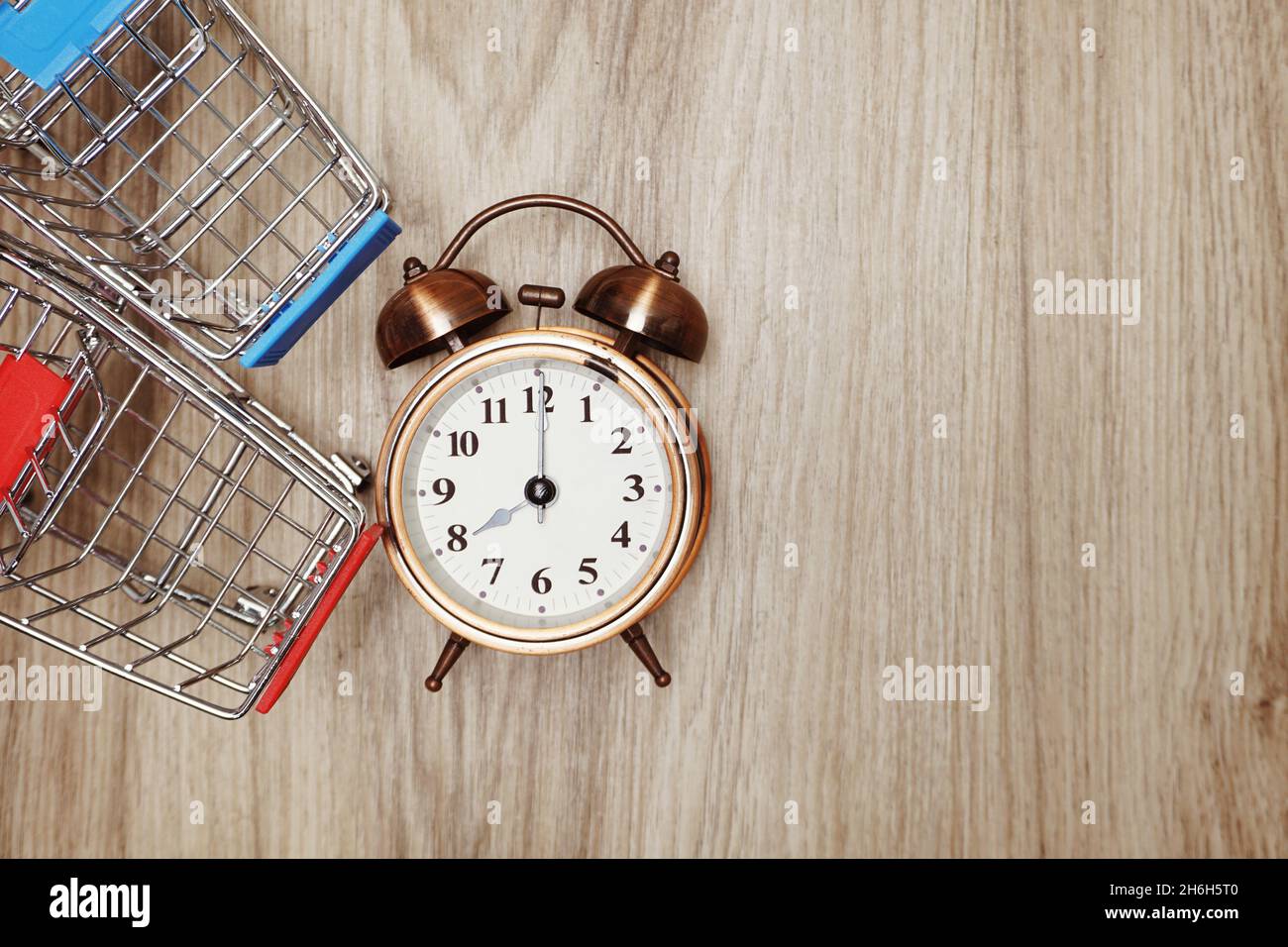 alarm clock and mini trolley cart with space copy on wooden background ...