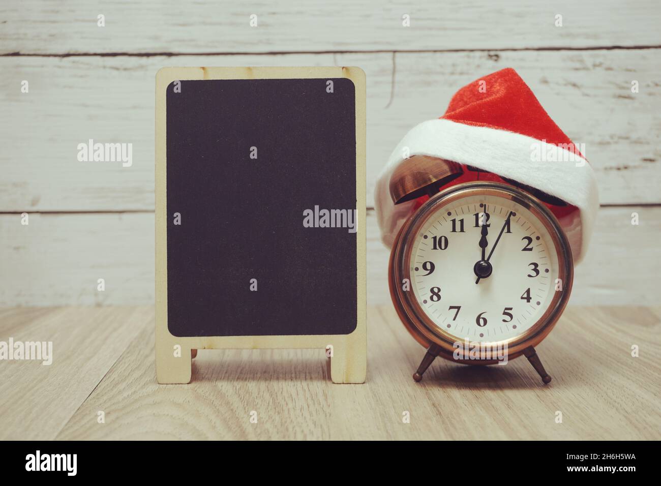 alarm clock with santa hat on wooen background time for christmas Stock ...