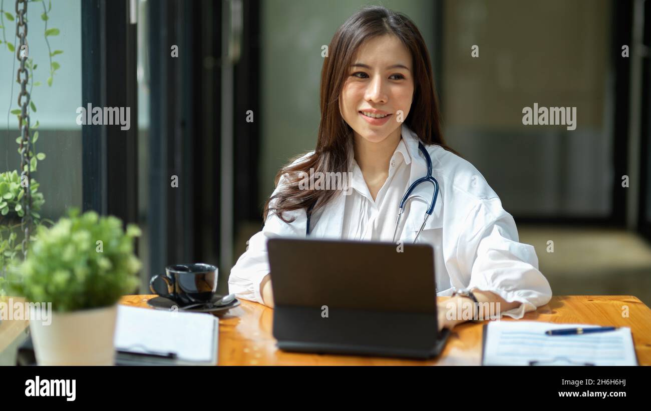 Happy young asian female physician using digital tablet computer in the ...