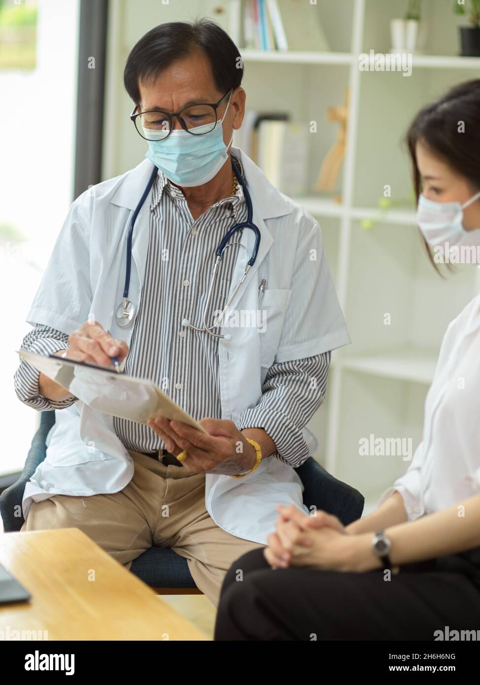 A professional aged male psychologist examines his patient in a medical ...
