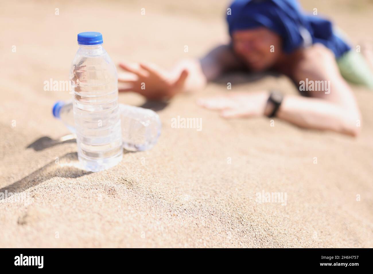 Man lying on sand in desert and feeling thirst Stock Photo - Alamy