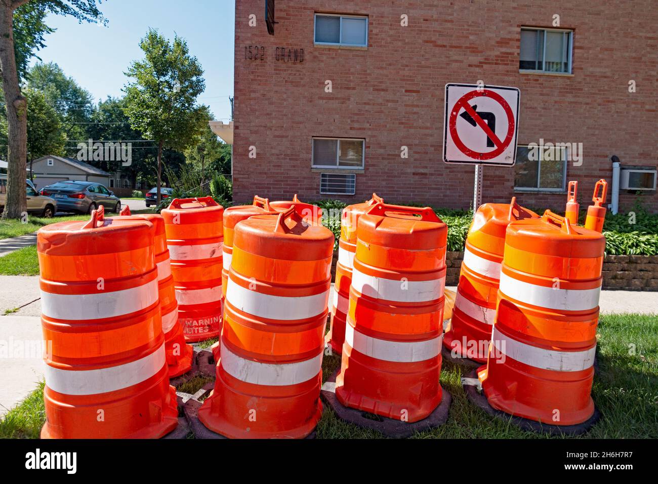 Orange and white striped road marker barrels grouped together in front ...