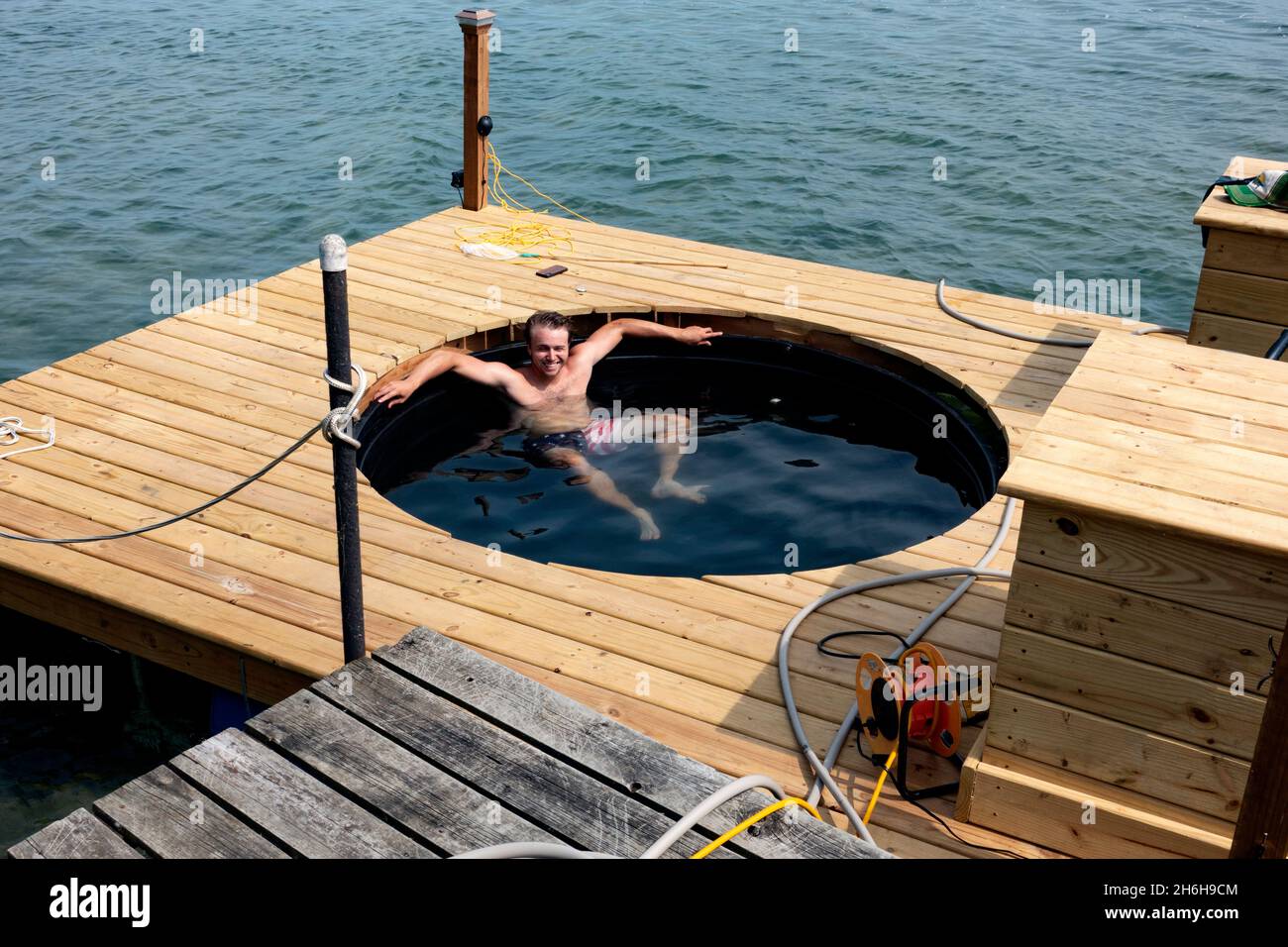 Man enjoying a soak in a hot tub on a boat that he built. Clitherall ...