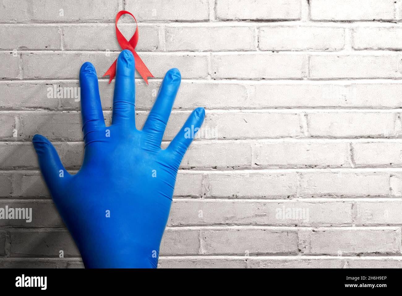 Red ribbon and medical glove with brick wall background. Hiv Aids ...